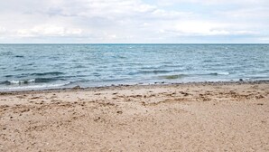 Uma praia com areal e mar.