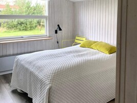 Quarto com cama, janela e abajur.