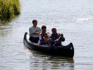 Um grupo de pessoas em um barco a remo em águas calmas.