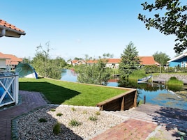 Zona residencial com piscina, cais para barcos e casas com telhados de telha vermelha.