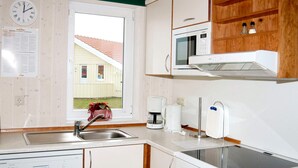 Cozinha equipada com lava-louças Siemens, micro-ondas, cafeteira e pia.
