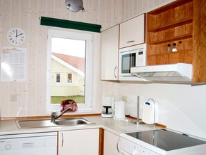 Cozinha equipada com lava-louças Siemens, micro-ondas, cafeteira e pia.