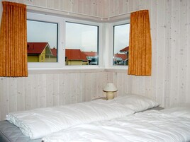 Quarto com cama, janela e abajur.