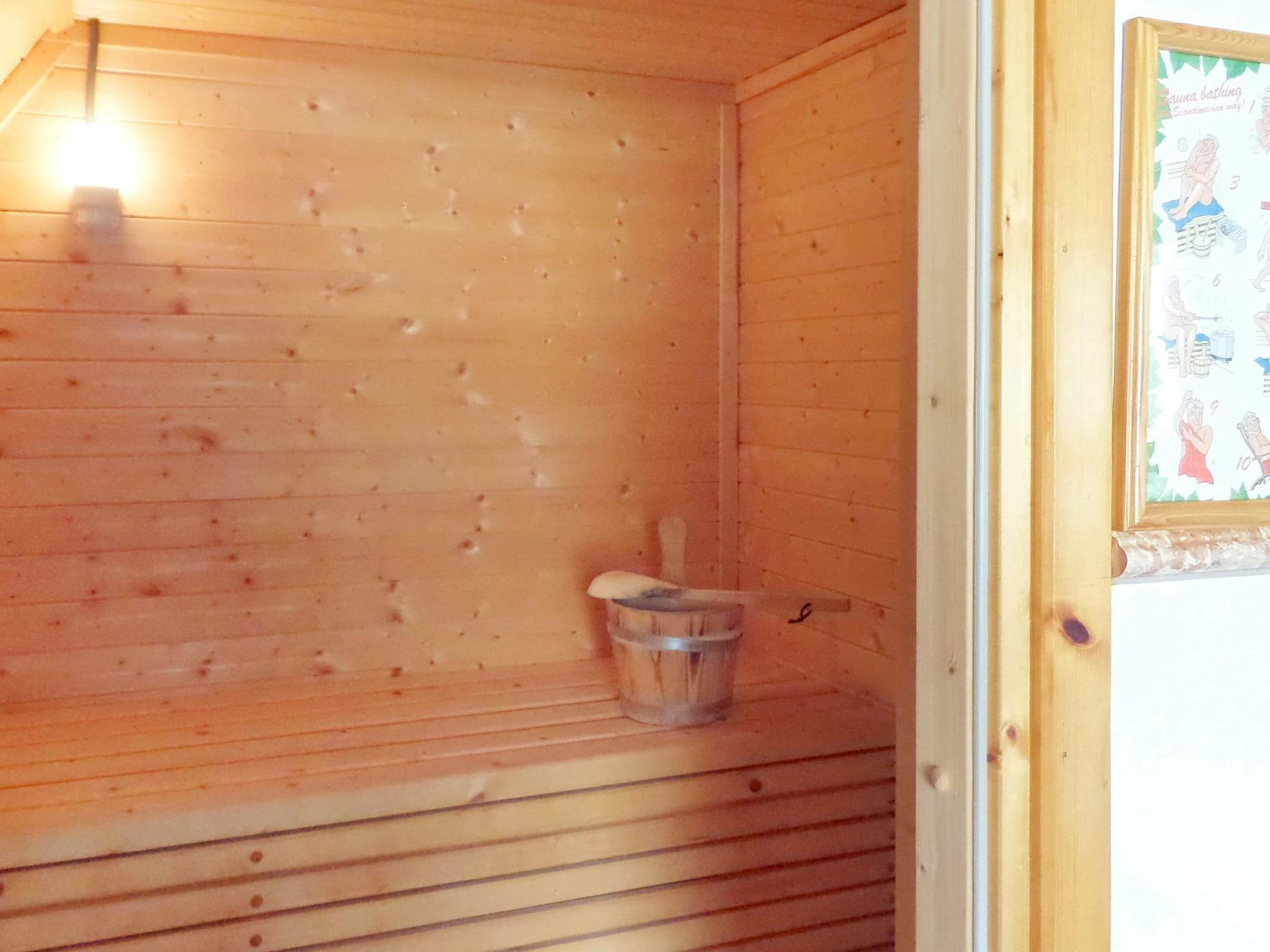 Uma sala de sauna com paredes de madeira e um banco.