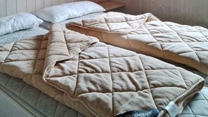 Uma cama com cobertor acolchoado e travesseiros.