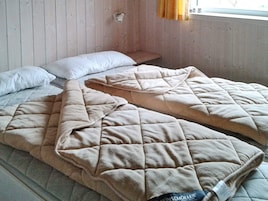 Uma cama com cobertor acolchoado e travesseiros.