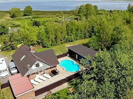 Um imóvel residencial com piscina, garagem separada e amplo gramado.