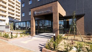 Exterior do Hotel Shinrin com design moderno, fachada de tijolos e amplas janelas de vidro.