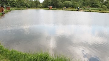 Um lago tranquilo com construções de madeira e vegetação ao redor.