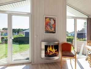 Quarto com lareira, pintura na parede e vista para o exterior.
