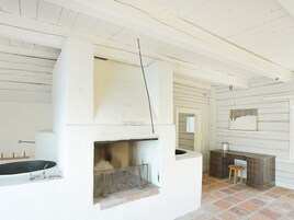 Um quarto com lareira, um banco de madeira e uma parede rústica.