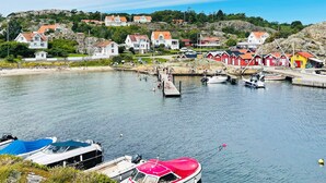 Uma vila costeira com casas, um cais e barcos.