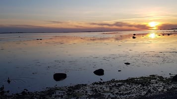 Paisagem plana e vasta com um corpo d'água calma refletindo o céu.