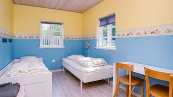 Quarto com duas camas, uma mesa e uma cadeira.