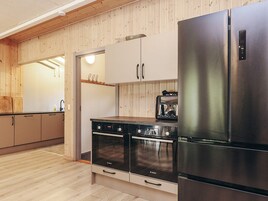 Uma cozinha com armários de madeira, forno Bosch, geladeira de aço inoxidável e uma torradeira.