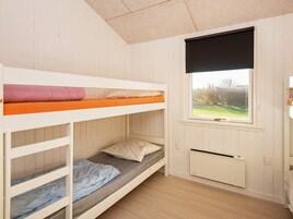Quarto com beliches, janela com vista e radiador.