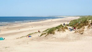 Uma praia com tendas e pessoas.