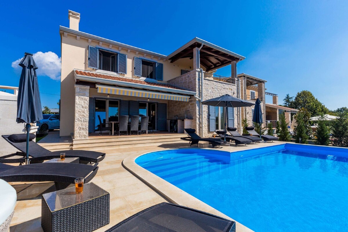 Uma villa moderna com piscina, área de estar ao ar livre e varanda coberta.