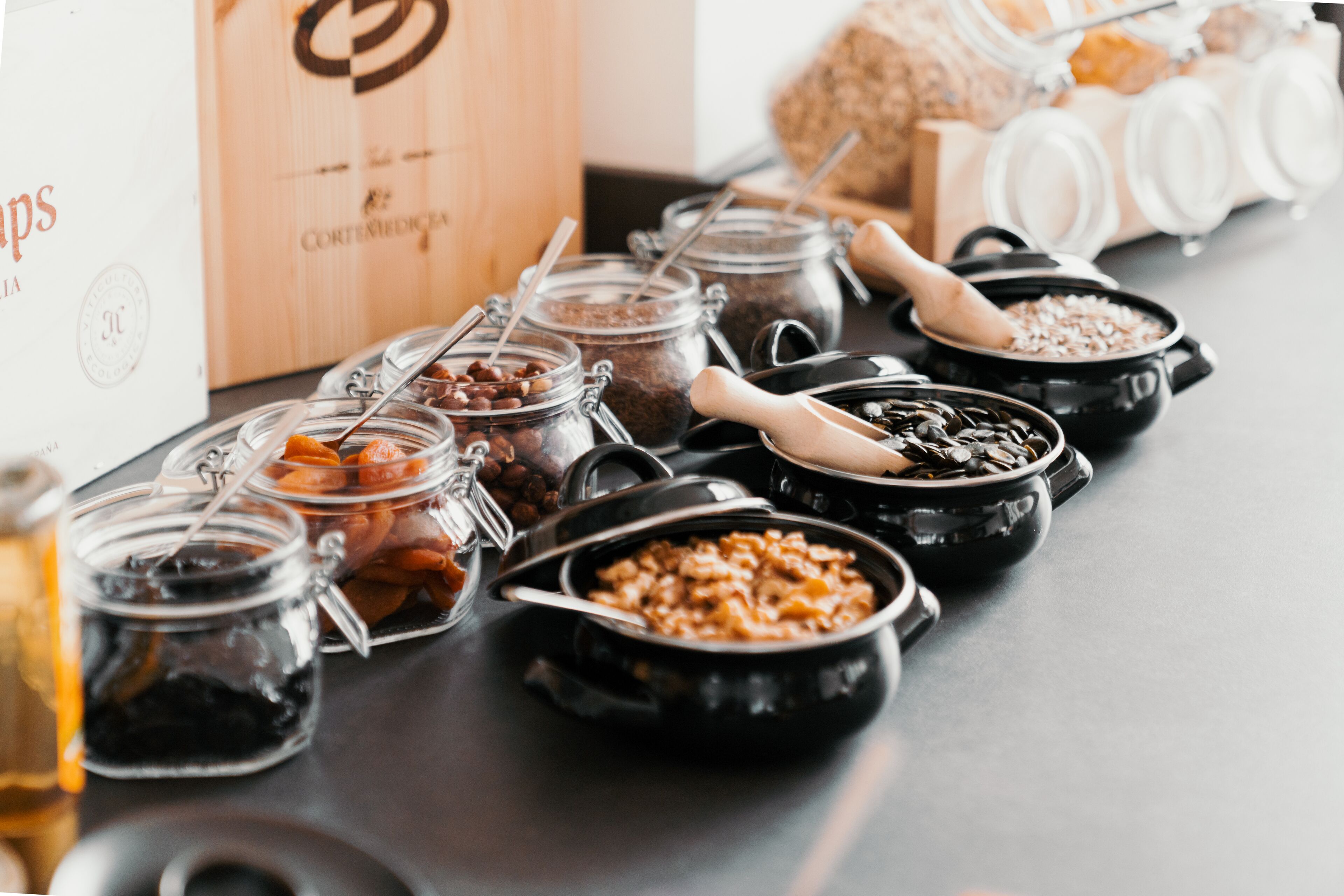 Uma mesa de buffet com diversos alimentos em potes e recipientes.