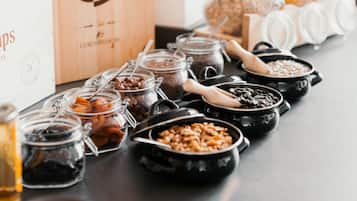 Uma mesa de buffet com diversos alimentos em potes e recipientes.