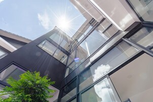 Um edifício moderno com grandes janelas de vidro e um céu claro.