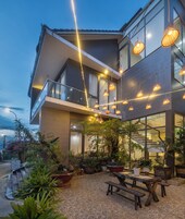 Um edifício moderno com varanda, área de estar ao ar livre e plantas em vasos.