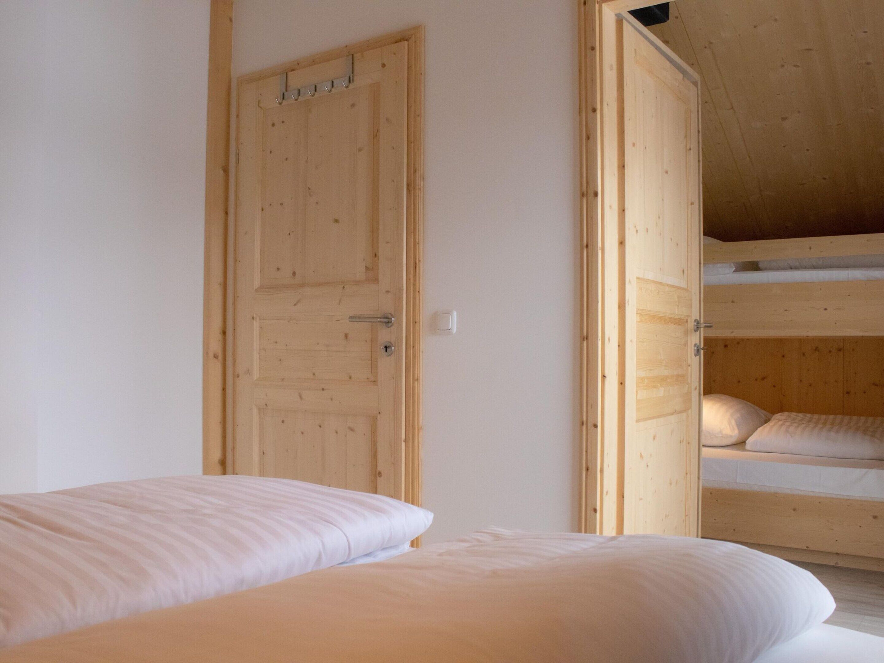 Um quarto com duas camas, uma no chão e outra em beliche.