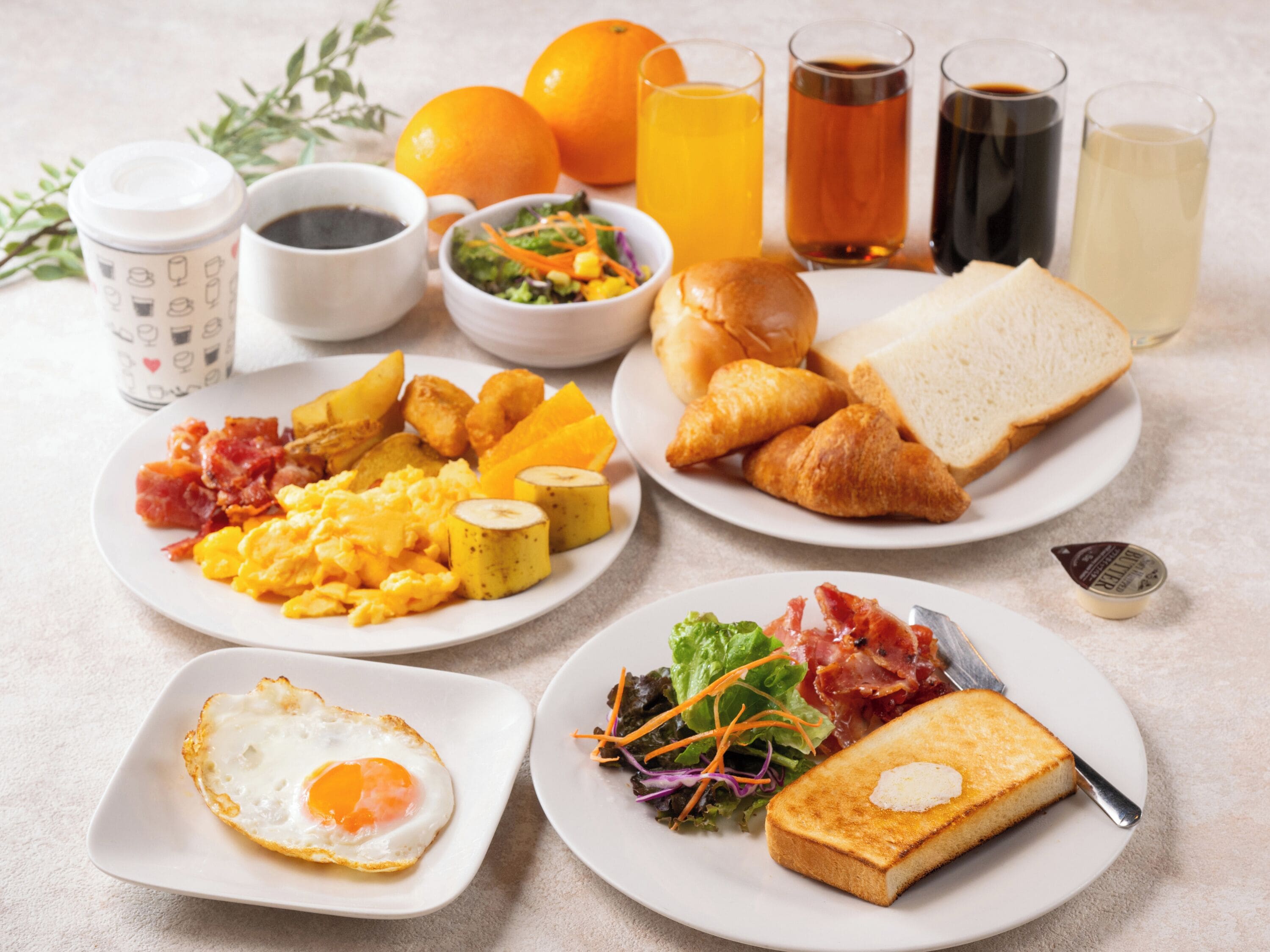 Uma mesa farta com diversos pratos, bebidas e uma xícara de café.