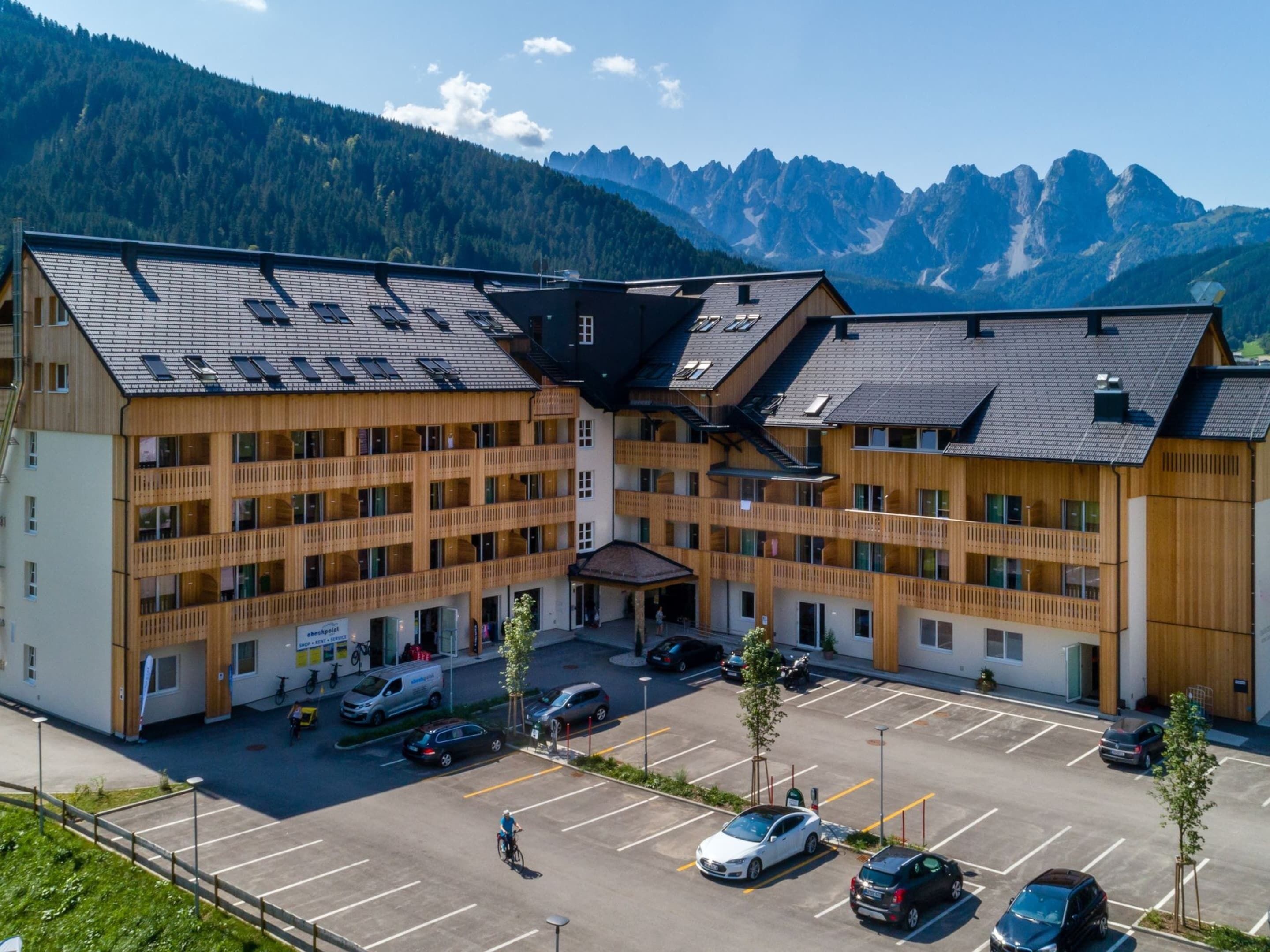 Um hotel com vários andares e um pátio central, rodeado por montanhas.