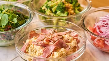 Diversos pratos de comida em recipientes de vidro transparentes sobre uma mesa.
