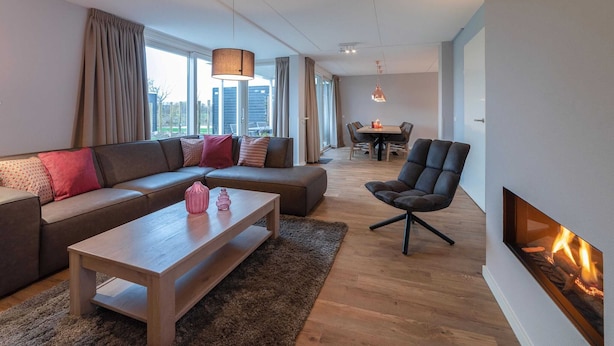 Uma sala de estar moderna com um sofá, mesa de centro e lareira.