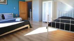 Quarto com cama, guarda-roupa e porta.