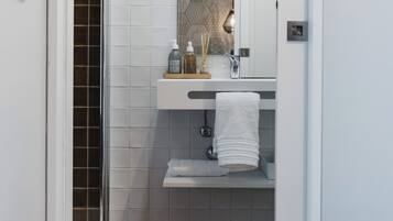 Um chuveiro fixo, um secador de cabelo, toalhas fornecidas, sabão