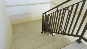 Uma escadaria com corrimão de metal e piso ladrilhado.