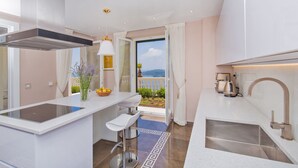 Cozinha moderna com ilha central, forno embutido e vista para o exterior.