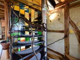 Uma escadaria em espiral com grades de metal e interior em madeira.