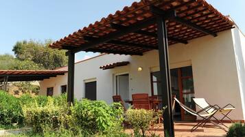Uma casa moderna com um pátio, área de estar externa e uma pérgola.