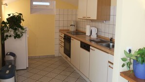 Uma cozinha compacta com geladeira, fogão, pia e armários.