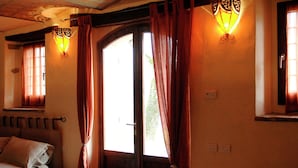 Quarto com cama, janela com cortinas e iluminação embutida na parede.
