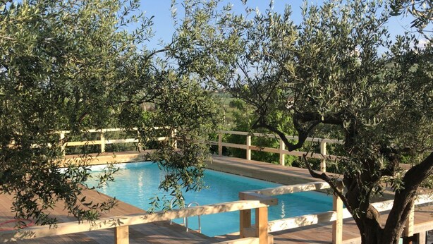 Uma piscina com um deck de madeira e cerca branca.