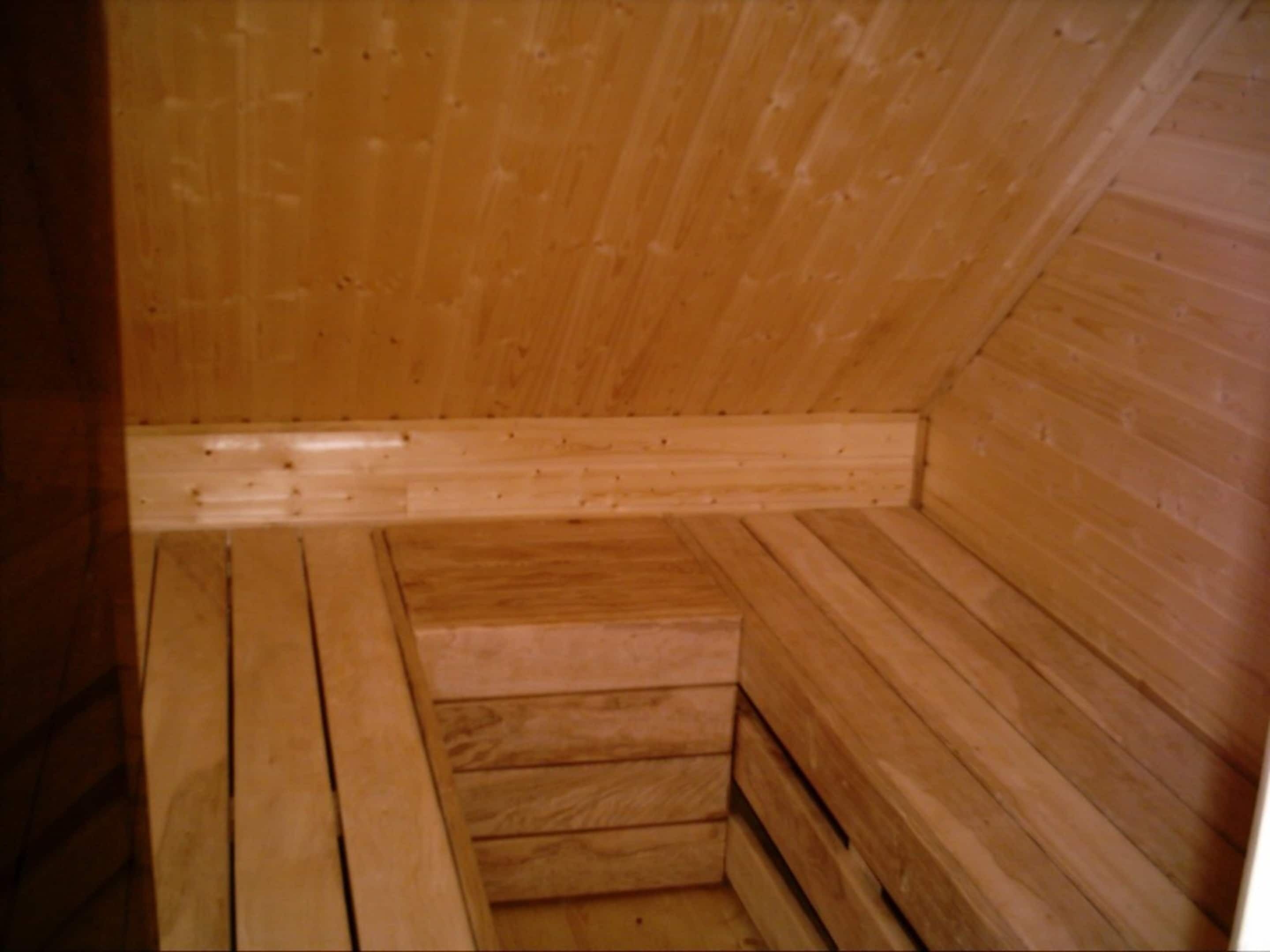 Uma sauna de madeira com bancos dispostos em semicírculo.