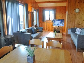 Uma sala de estar aconchegante com um sofá, uma mesa de jantar e uma televisão.