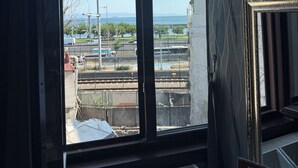 Janela com vista para um trilho de trem e céu claro.