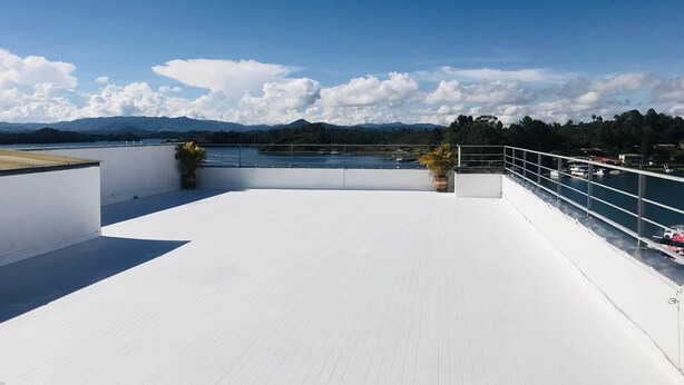 Terraço no telhado com vista desobstruída para um lago e montanhas.