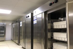 Uma fileira de refrigeradores de aço inoxidável com prateleiras internas, provavelmente para armazenamento de alimentos.