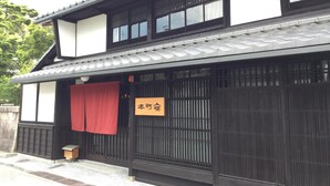 Um edifício japonês tradicional com uma placa que diz 'Hotel'.