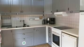 Um frigorífico no espaço comum, um micro-ondas, uma placa de cozinha