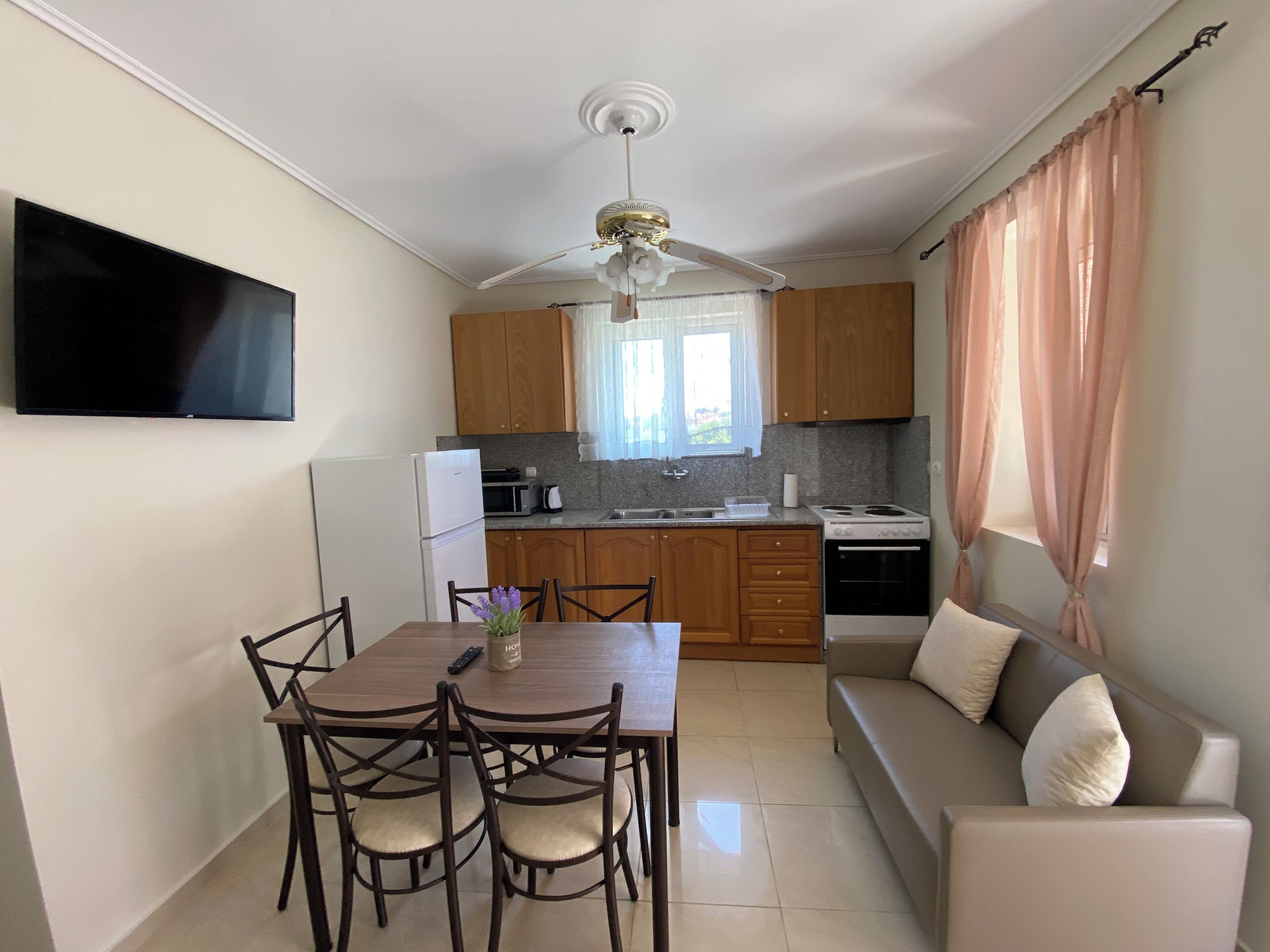 Espaço compacto com área de jantar, cozinha compacta e sofá.