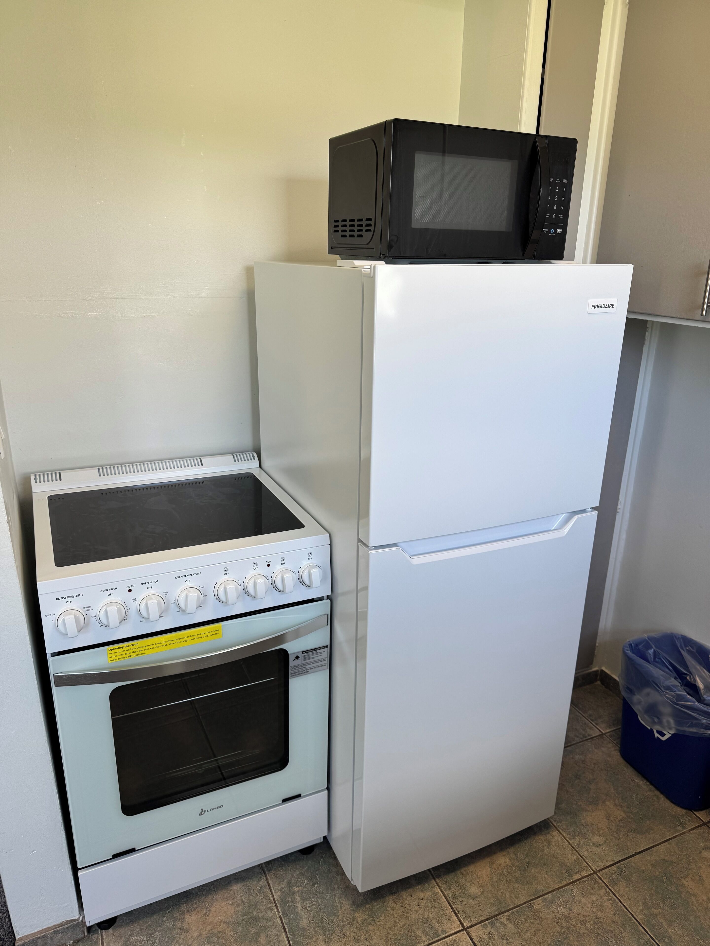 Uma cozinha compacta com forno embutido, micro-ondas e frigorífico.
