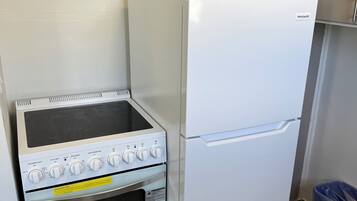 Uma cozinha compacta com forno embutido, micro-ondas e frigorífico.